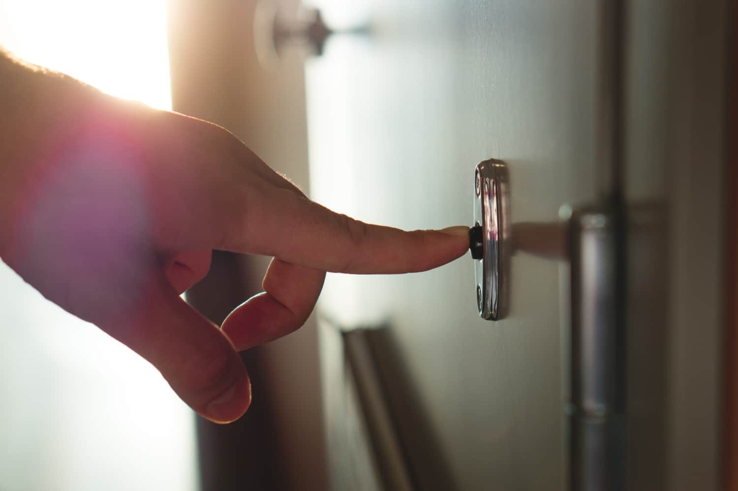 Finger pressing doorbell in sunny apartment building corridor. Close up ... Finger pressing doorbell in sunny apartment building corridor. Close up ...
